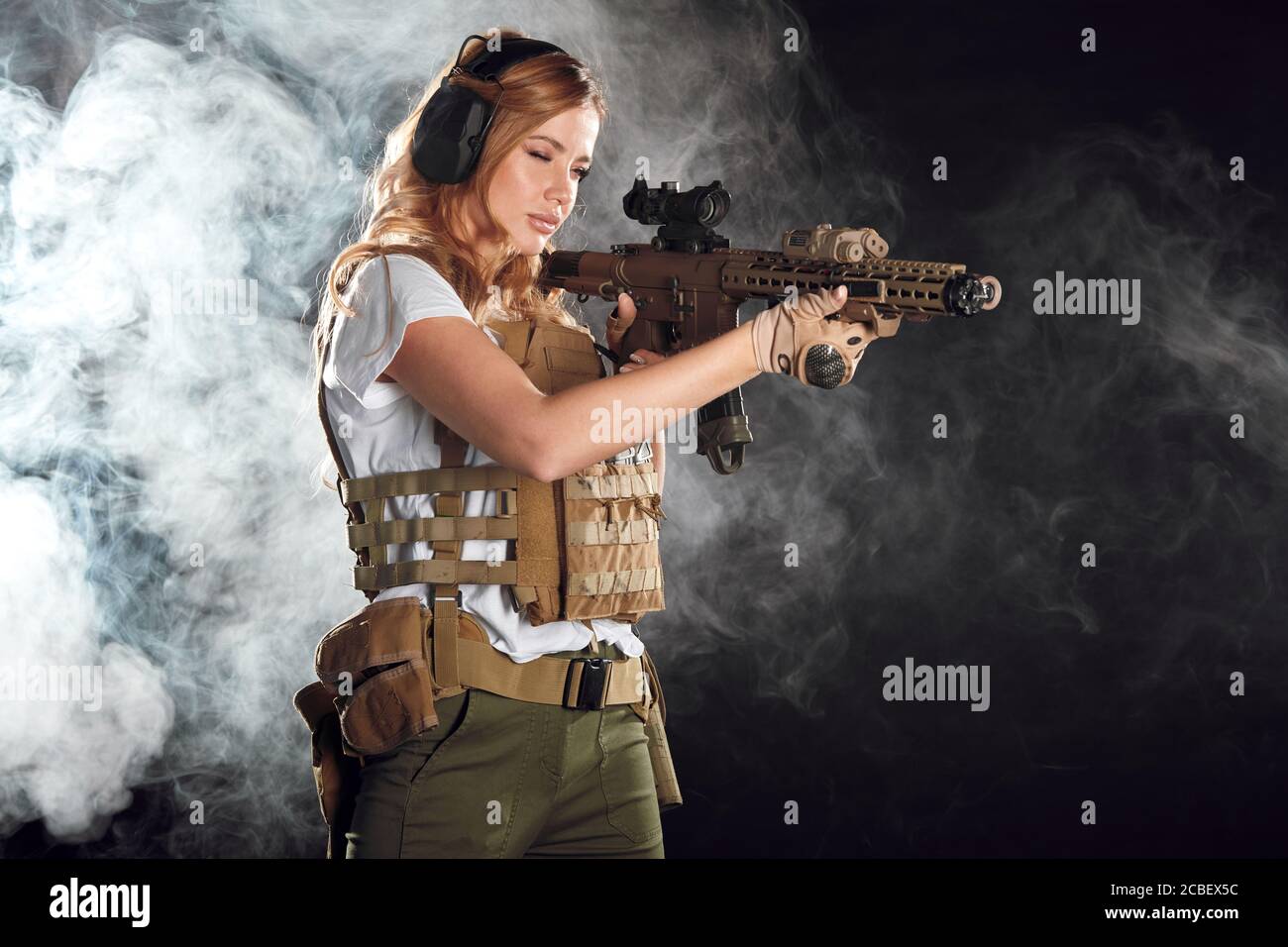 Girl marksman in sniper gear holding sniper rifle in hand aiming at ...