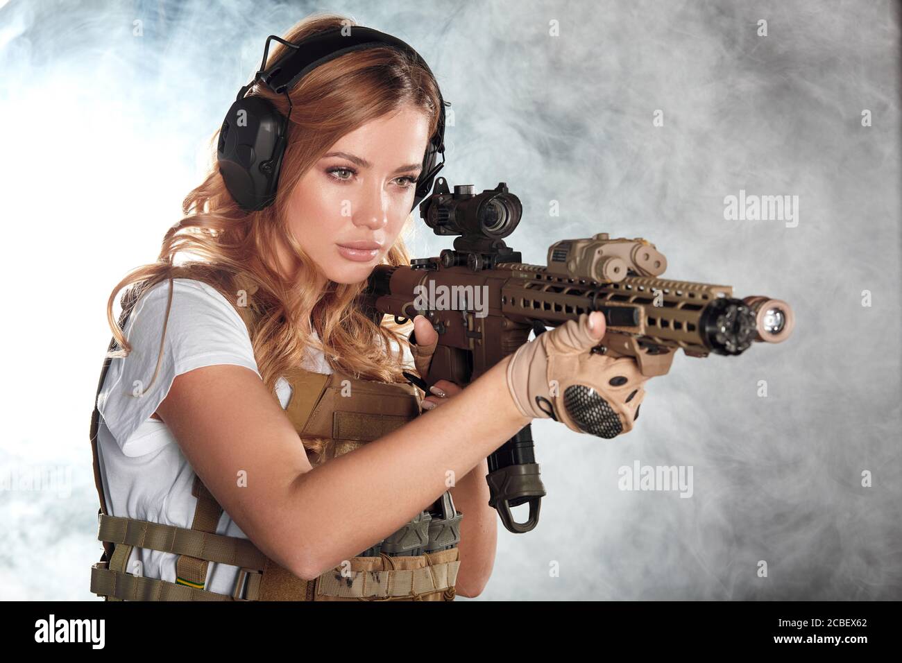 Girl marksman in sniper gear holding sniper rifle in hand aiming at ...