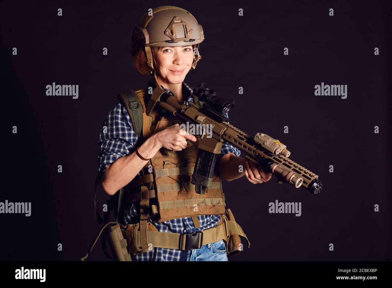 Female civil in tactical uniform with rifle. Shot in studio on black ...