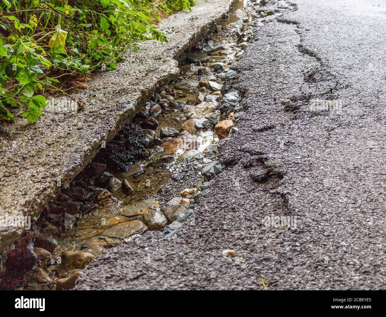 Road Surface damaged and washed away by storm flood waters Stock Photo ...