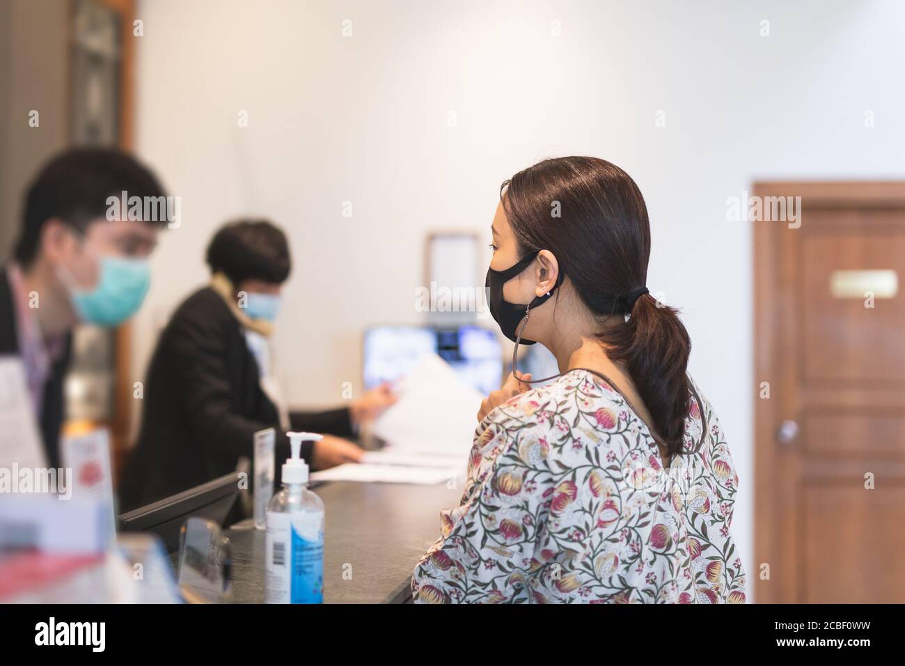 Woman client check in at hotel reception wearing medical masks Stock ...