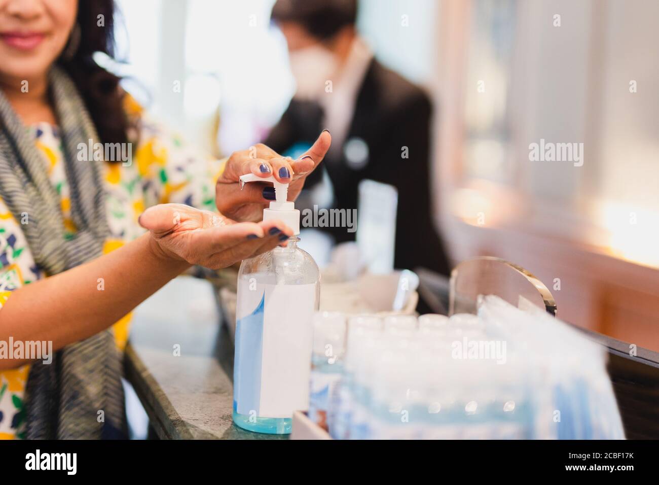 Woman hand washing alcohol gel in hotel front desk for stop covid 19 ...