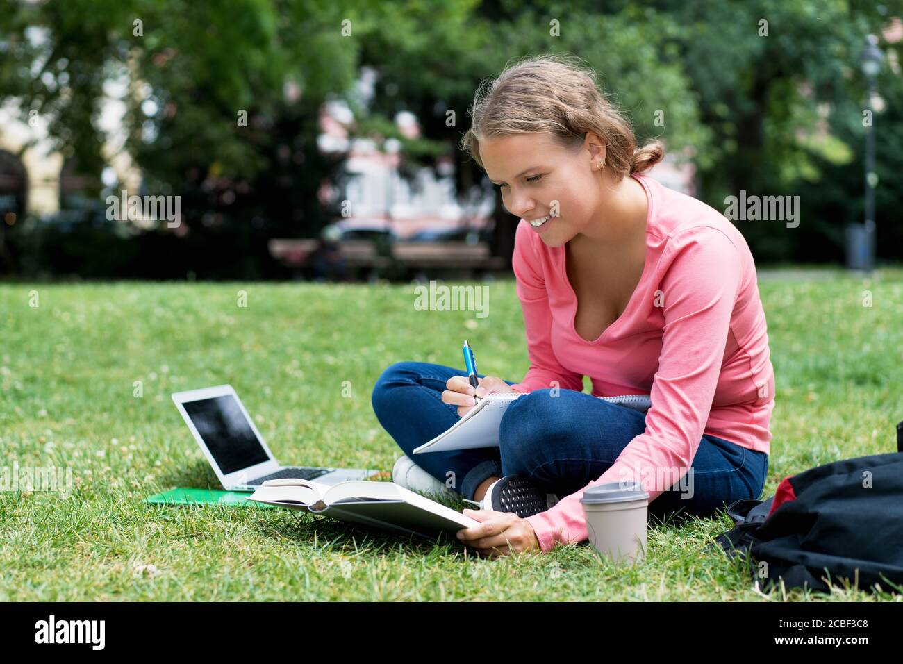 Laughing german female student learning and preparing for degree ...