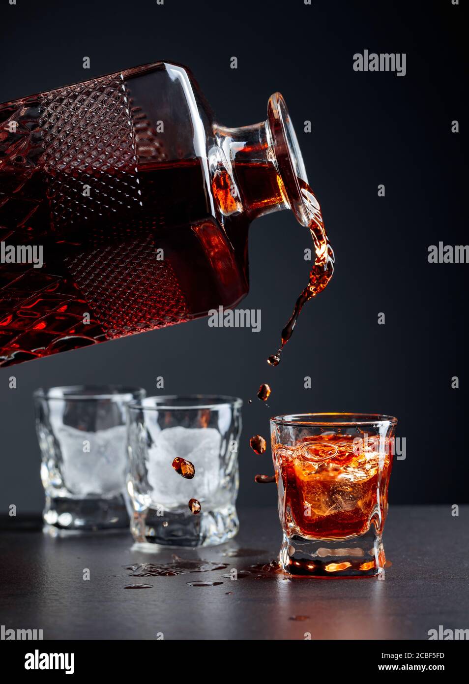 Whiskey pours into a steamed glass with natural ice. Alcoholic drink is ...