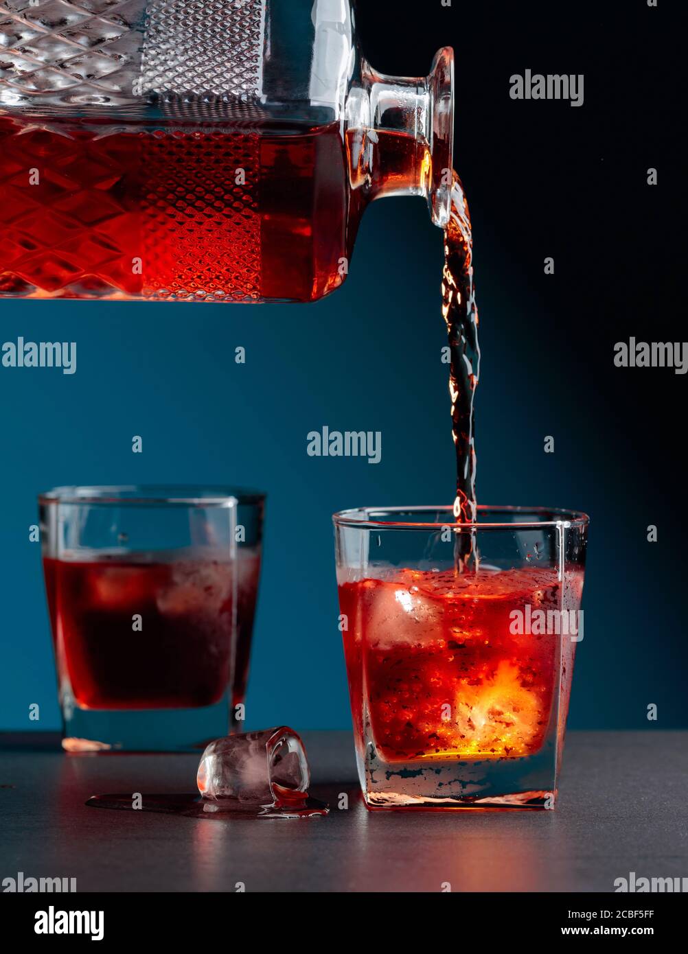 Whiskey pours into a steamed glass with natural ice. Alcoholic drink is ...