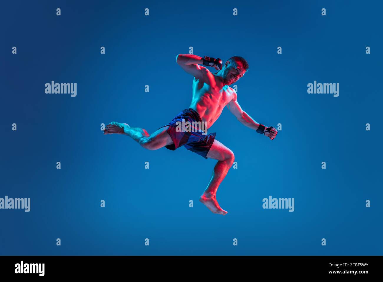 High flight. MMA. Professional fighter punching or boxing isolated on ...