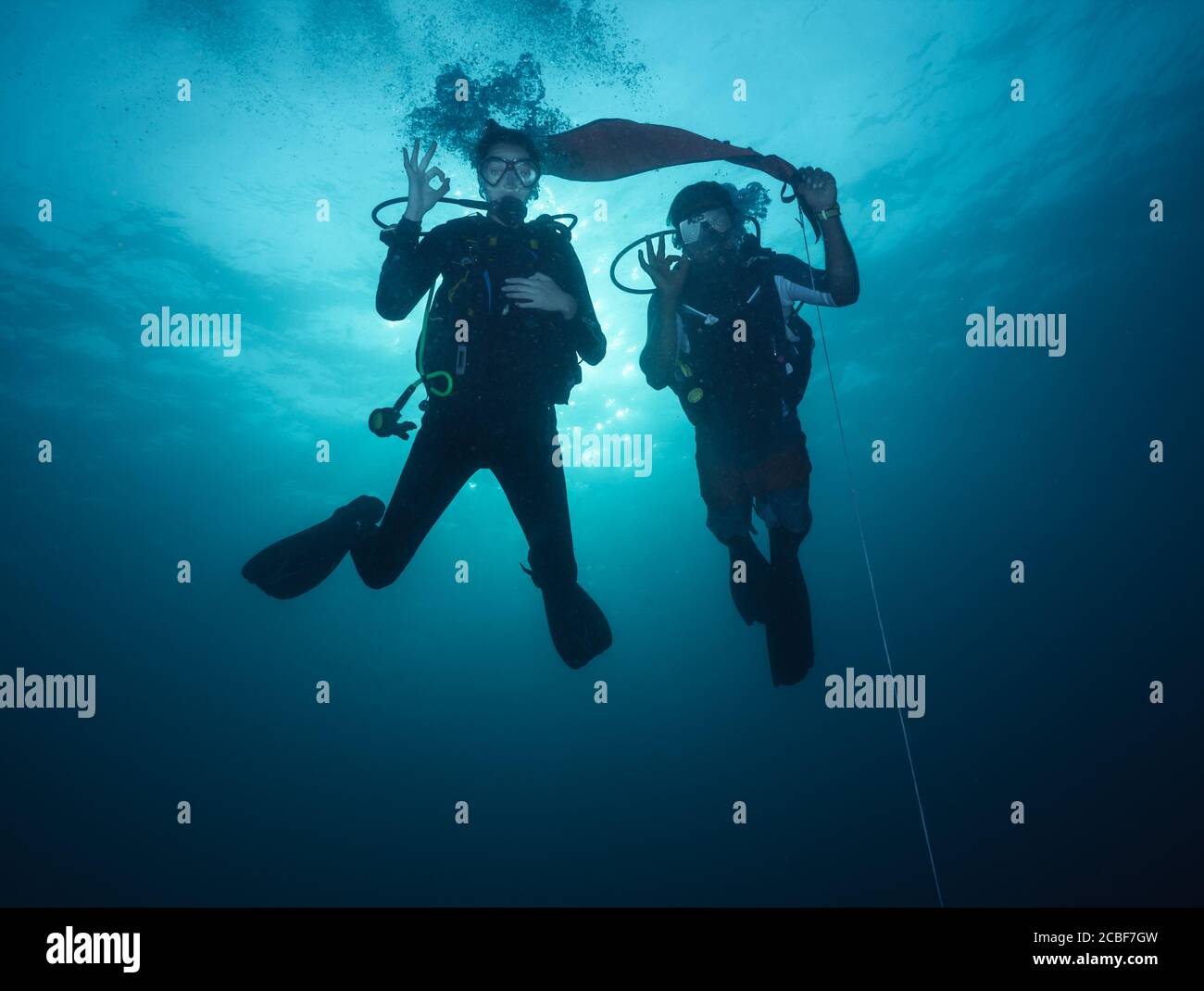 Young woman and man scuba divers waiting on safety stop. Underwater ...
