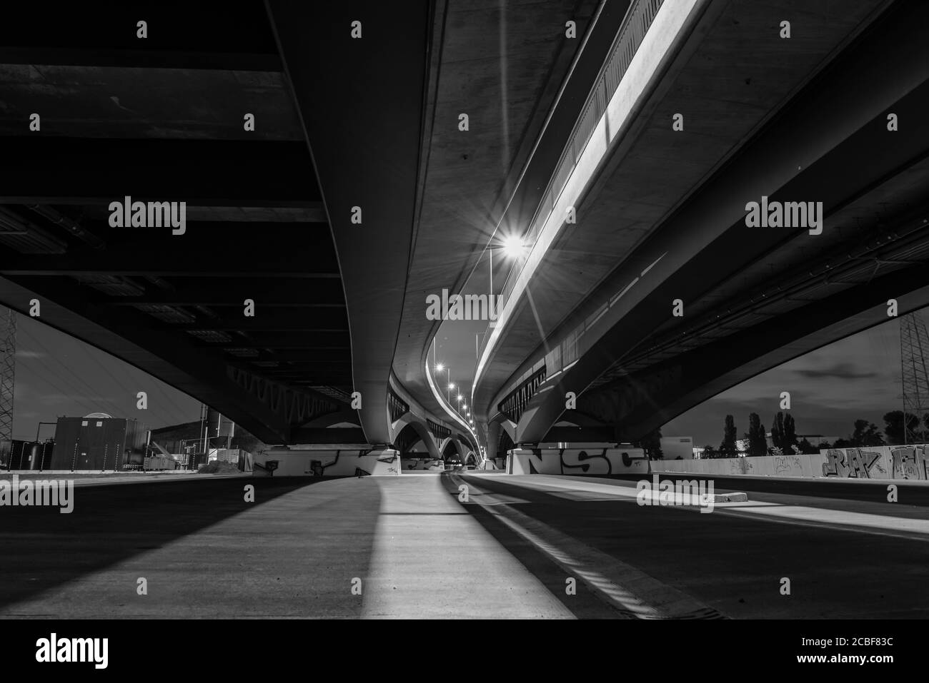 Under a large bridge at night, a massive bridge construction at night ...