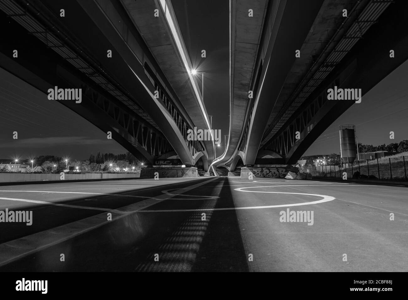 Under a large bridge at night, a massive bridge construction at night ...
