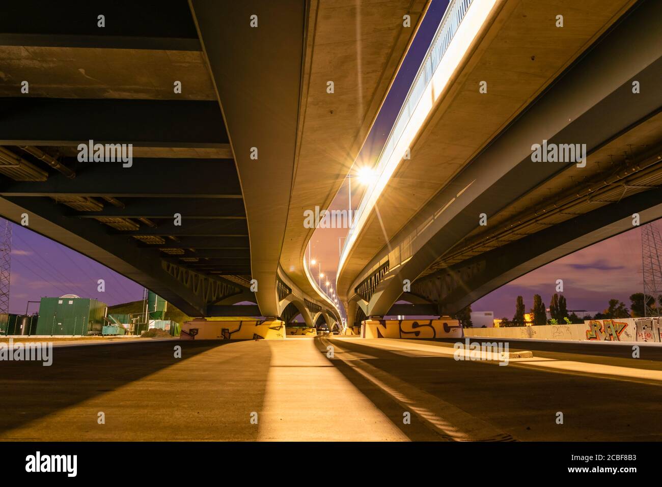 Under a large bridge at night, a massive bridge construction at night ...