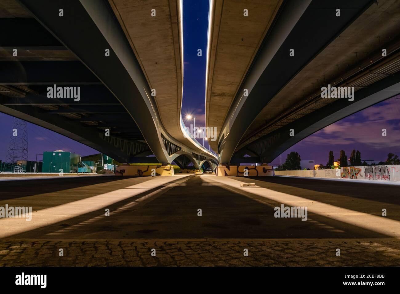 Under a large bridge at night, a massive bridge construction at night ...