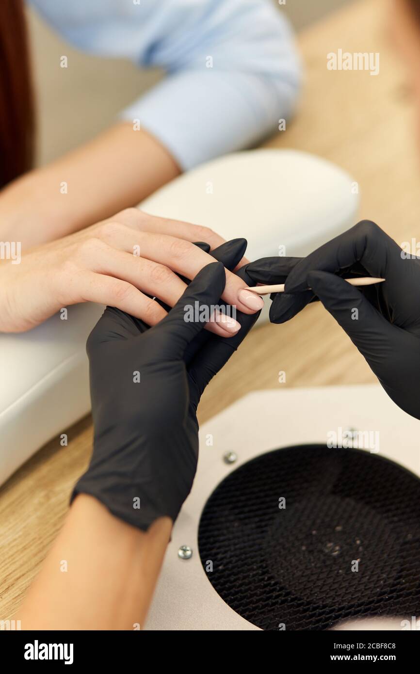 Manicurist work with client's nails at table. Nail master holding ...