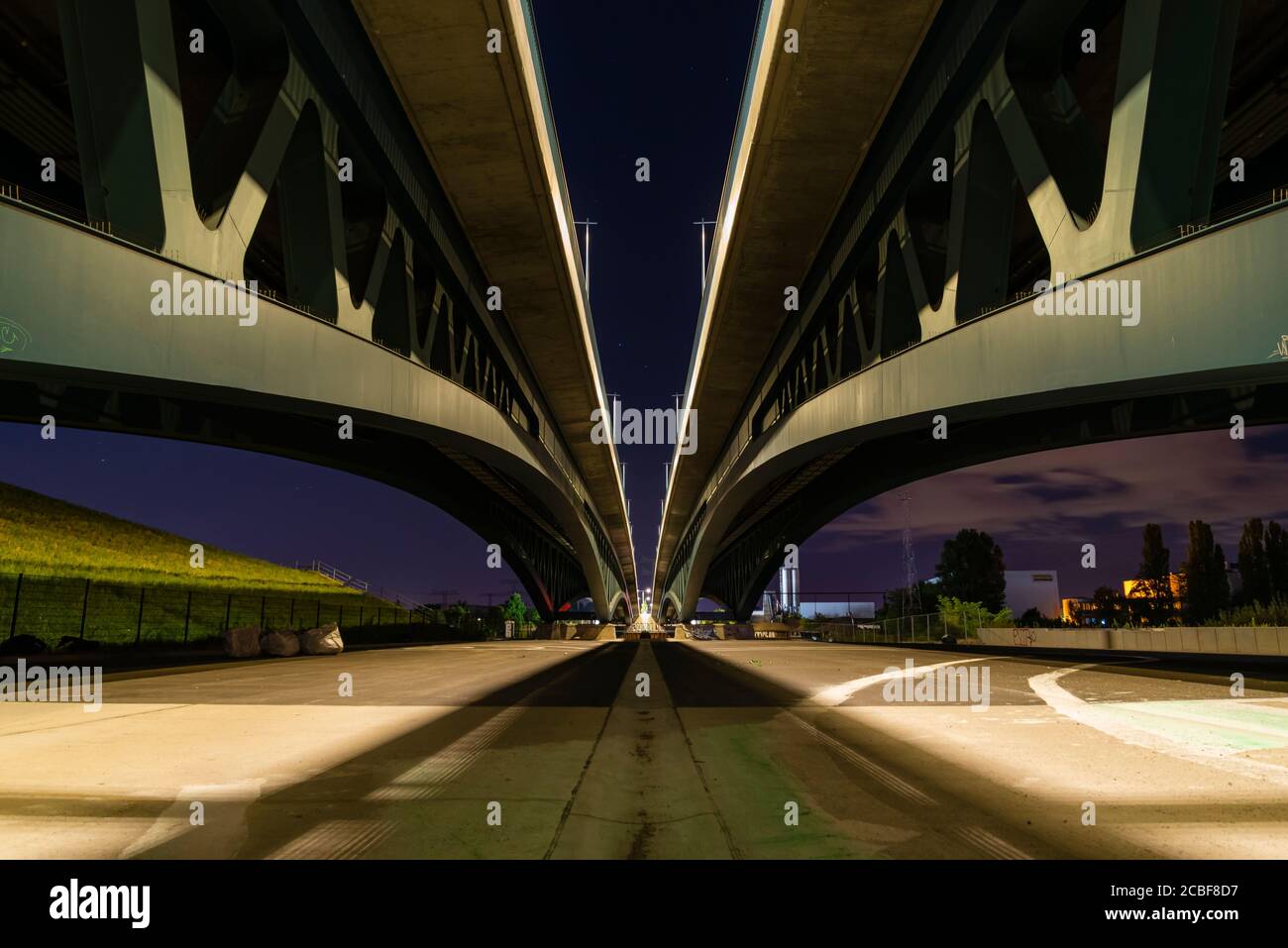 Under a large bridge at night, a massive bridge construction at night ...