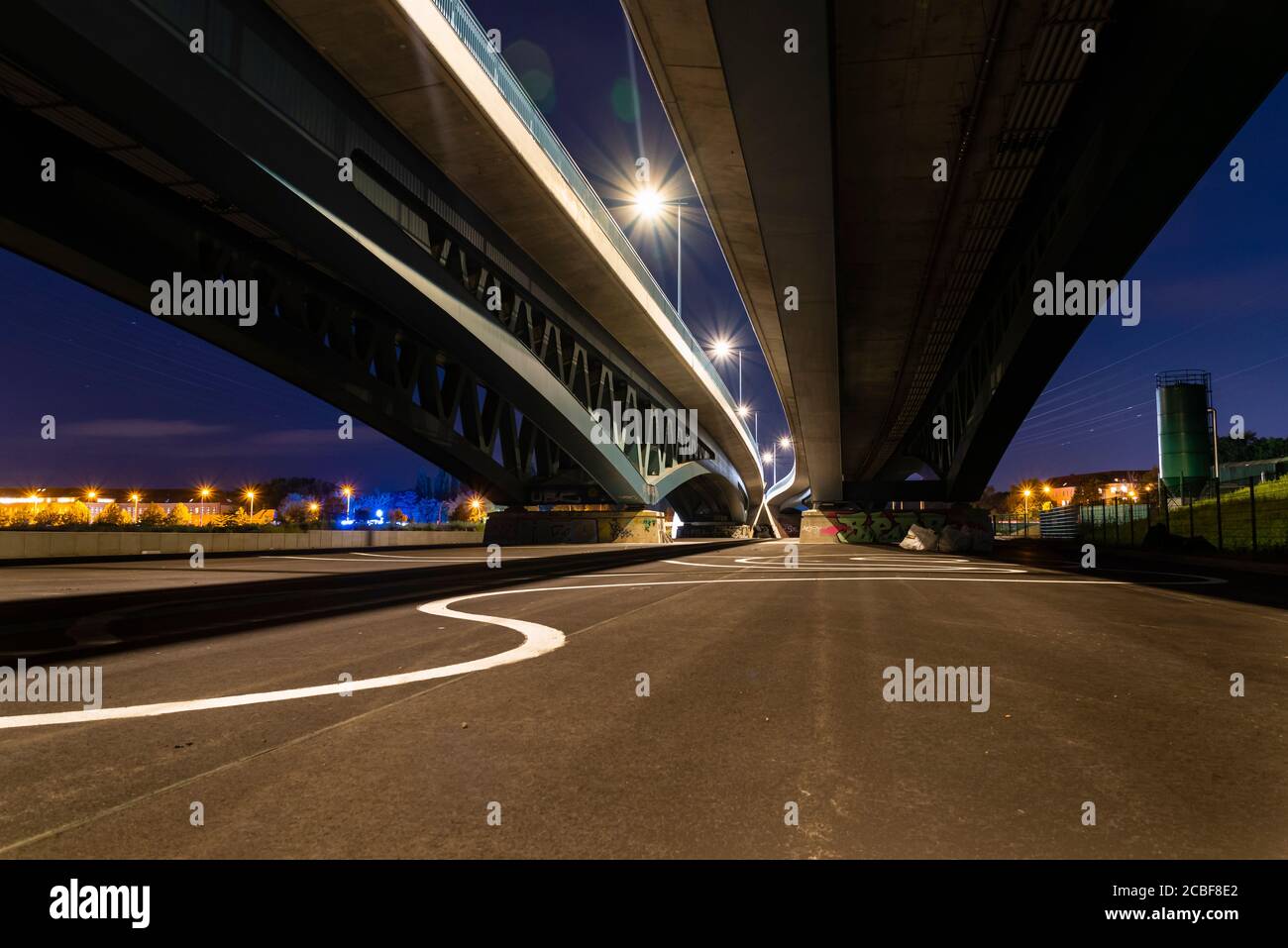 Under a large bridge at night, a massive bridge construction at night ...