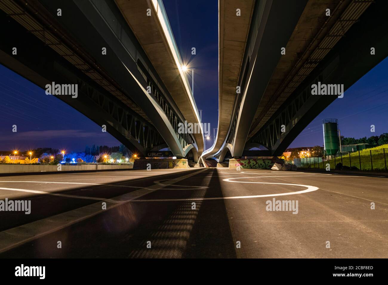 Under a large bridge at night, a massive bridge construction at night ...