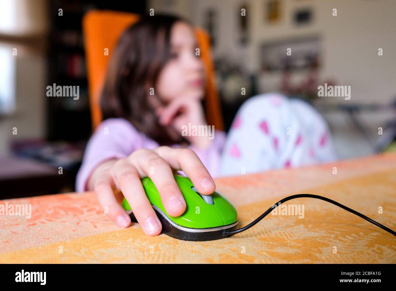 The child is sitting on a chair, studying at the computer. Study at ...