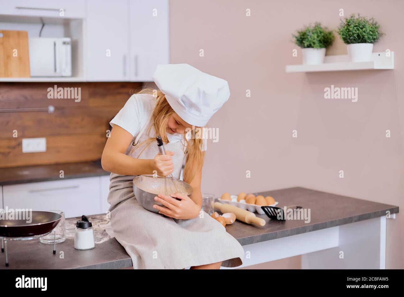 diligent and sedulous little girl cook and bake independently, make ...