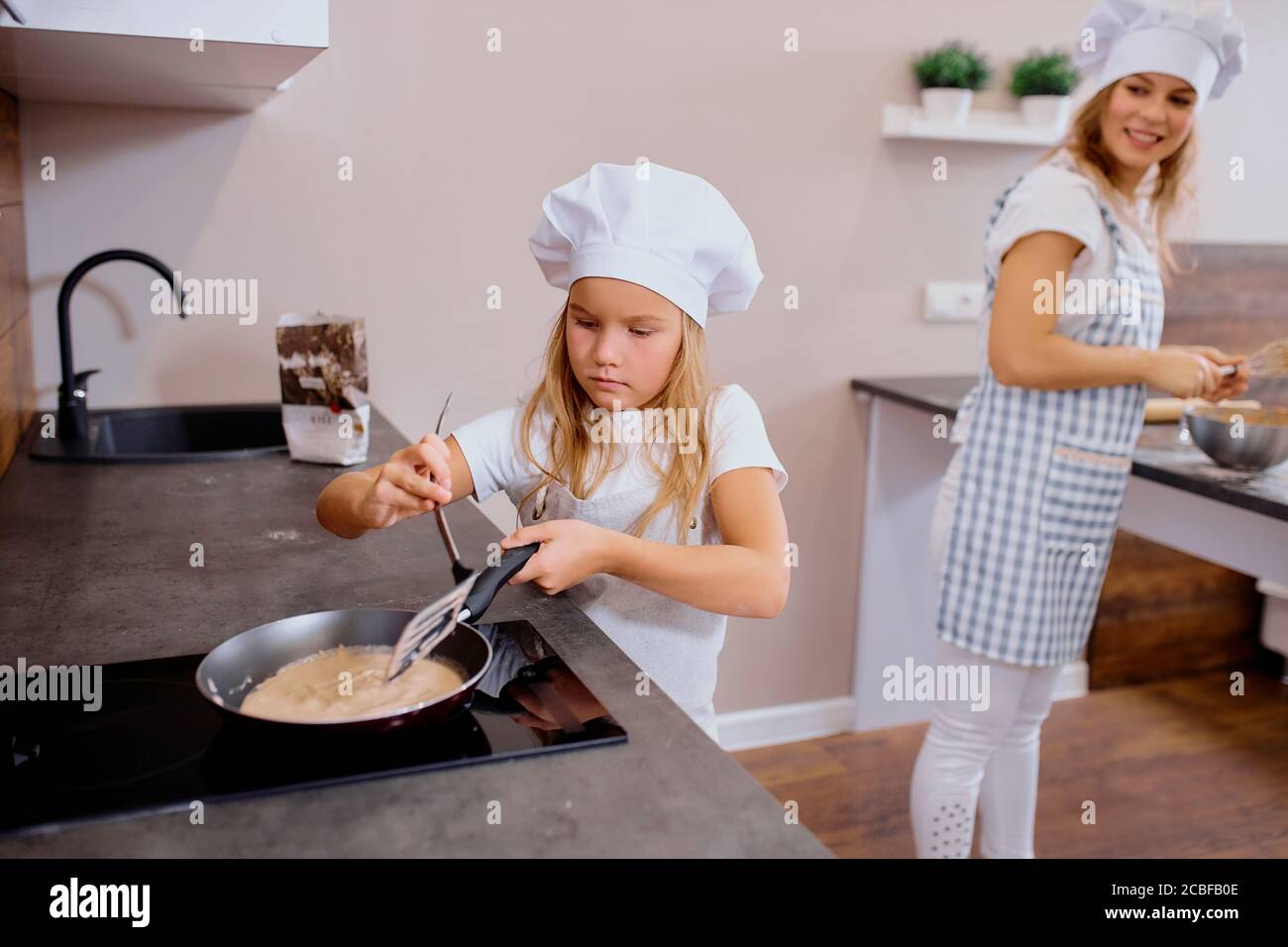 diligent and sedulous little girl cook and bake independently, make ...