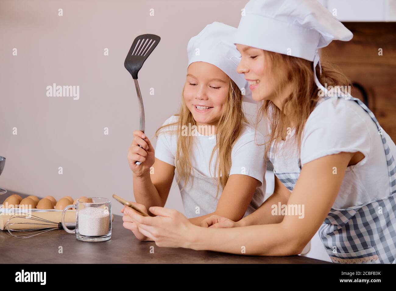 Daughter watching mother cook hi-res stock photography and images - Alamy