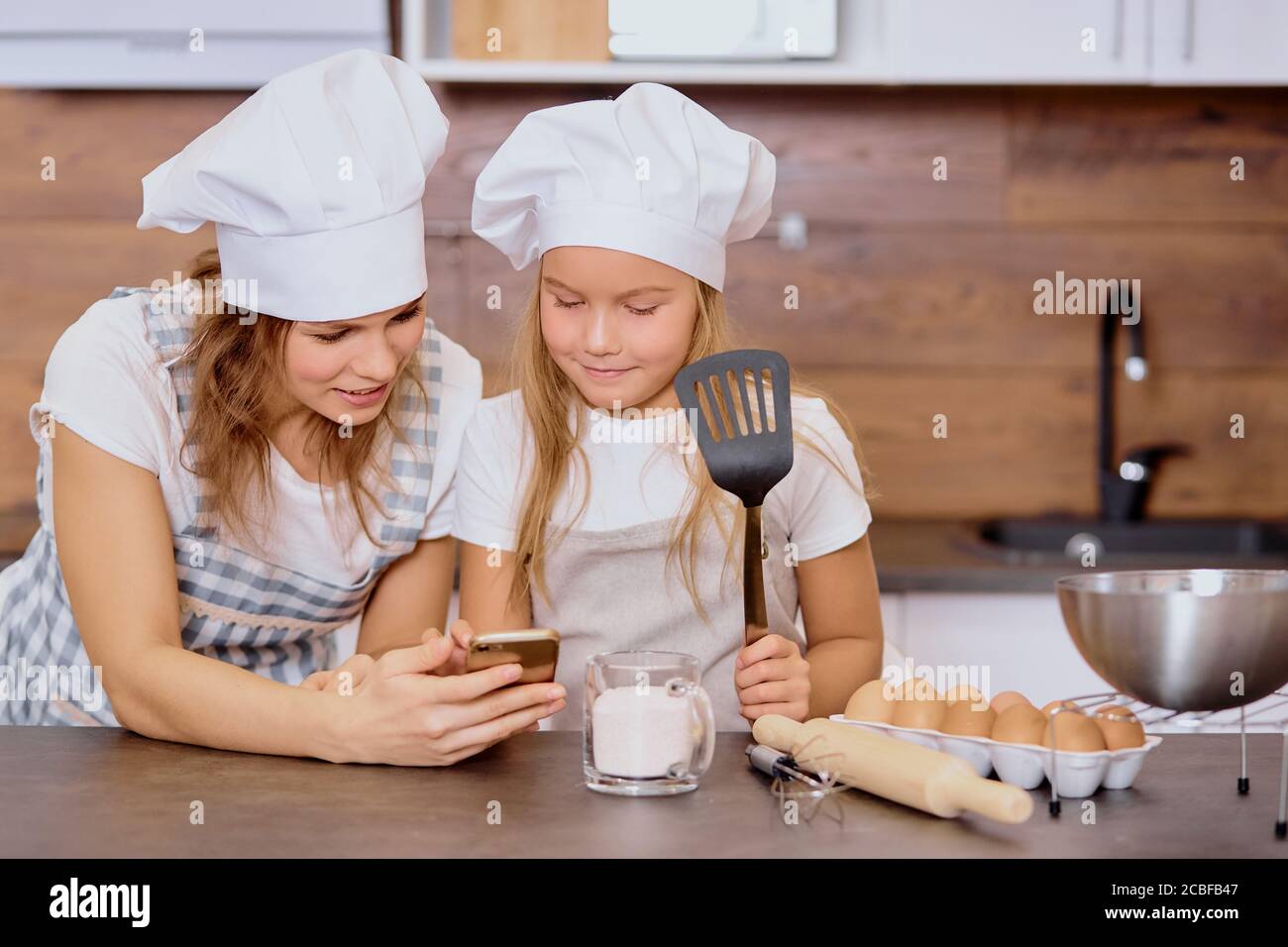 Daughter watching mother cook hi-res stock photography and images - Alamy