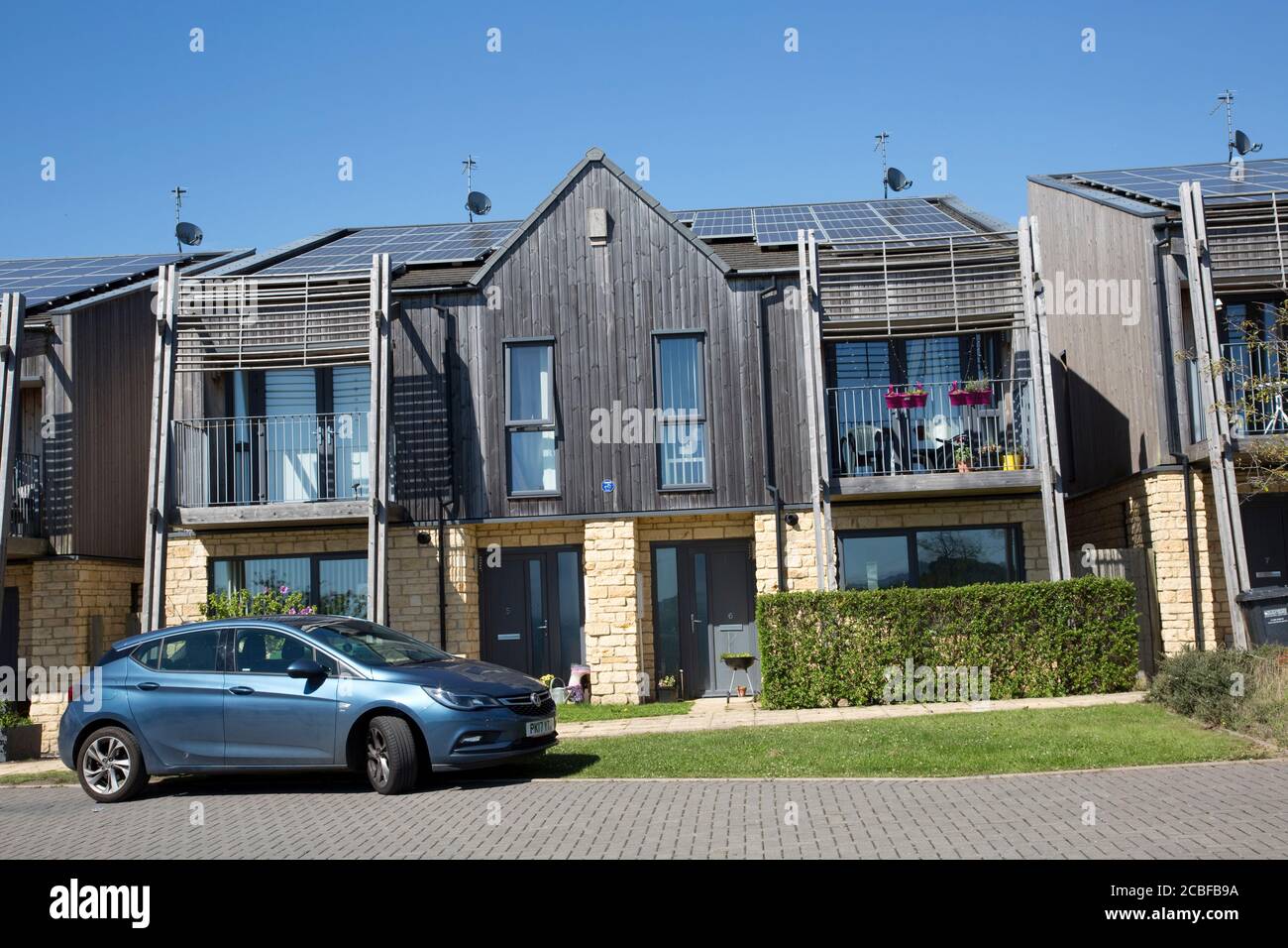 Sustainably built terraced houses, lower section in Cotswold stonem ...