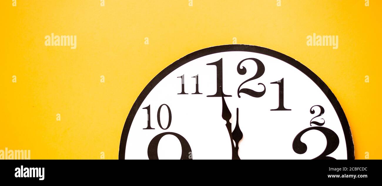 Black and white clock showing one minute to midnight, isolated on ...