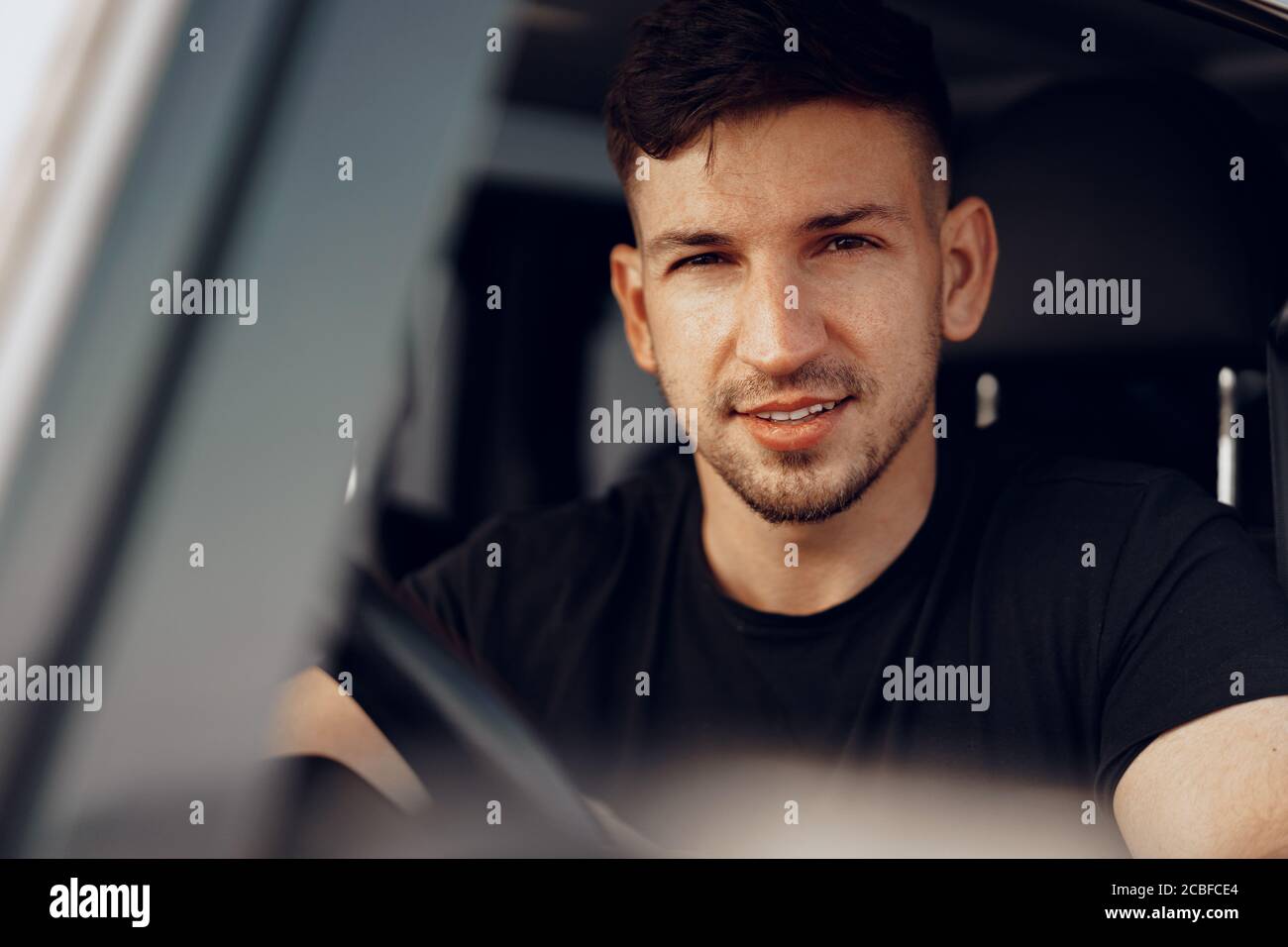 Handsome young man driver looking through the window of his off-road ...