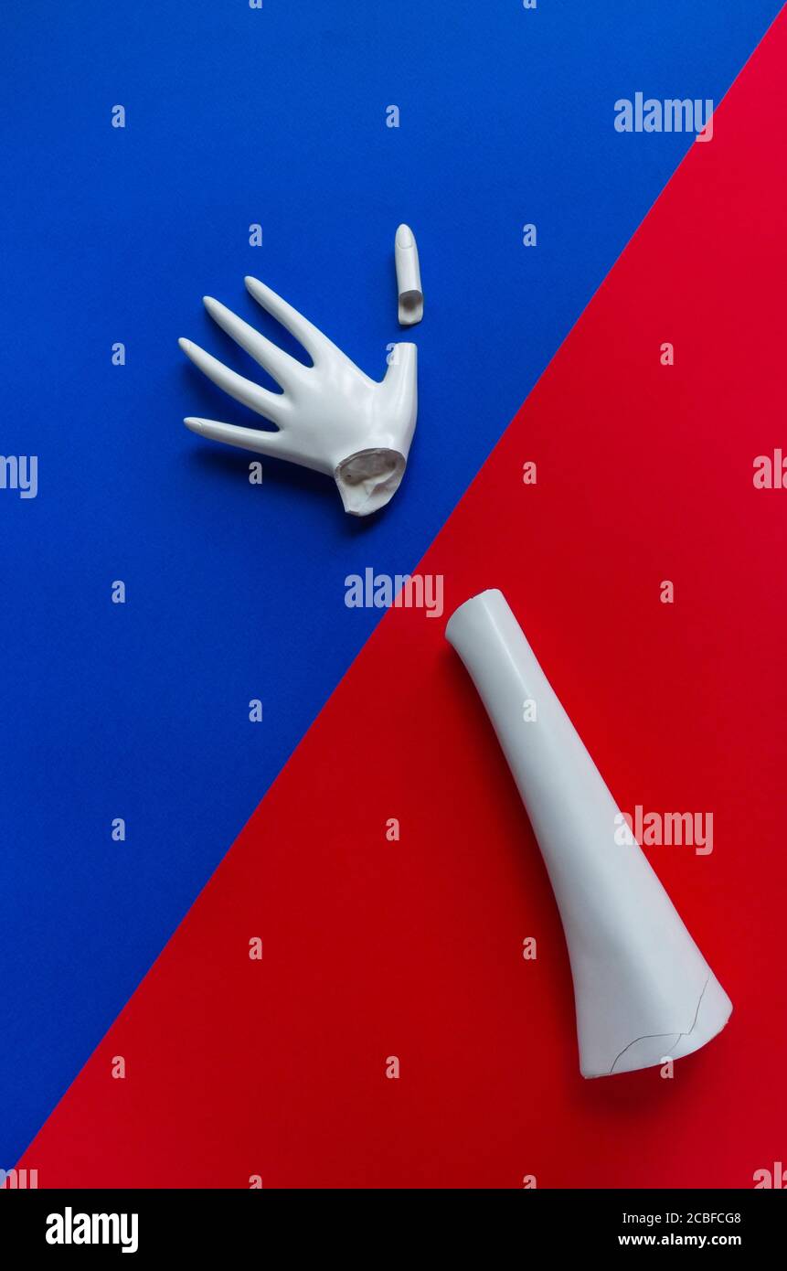 Broken white plaster hand. Medical concept on a red-blue background ...