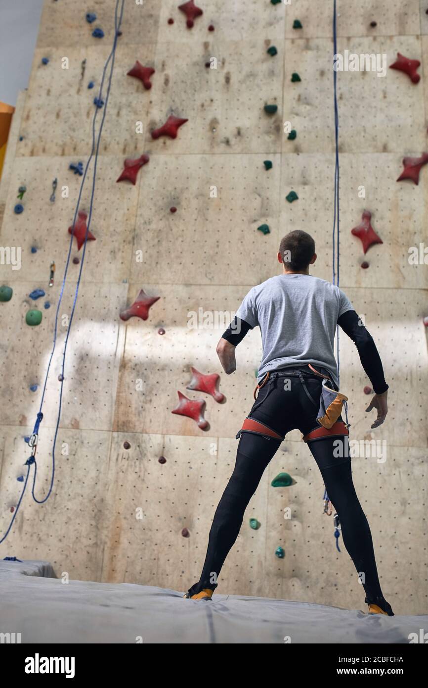 Full length back view of strong motivated rock-climber without forearm ...