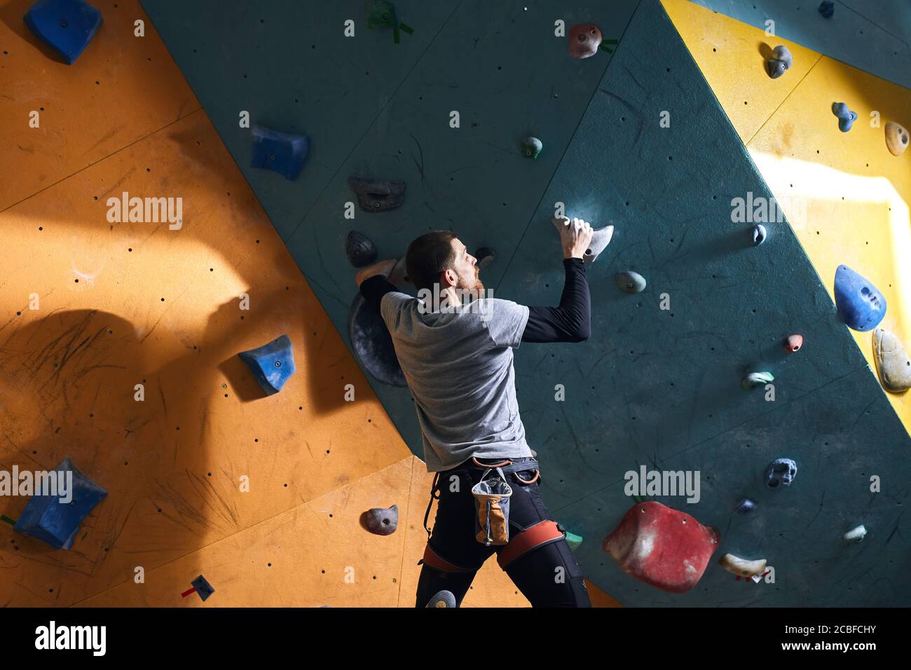 Rare view of unrecognizable male rock-climber with physical disability ...