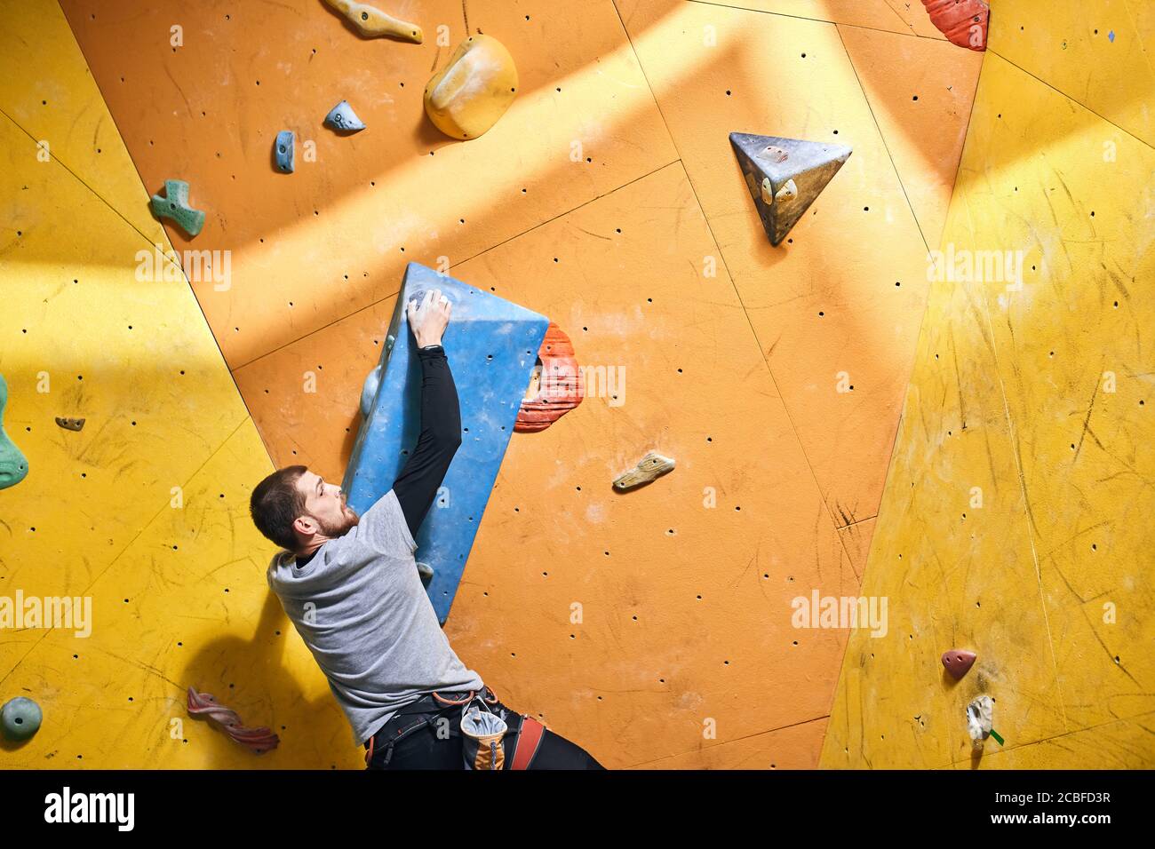 Cropped shot of young strong physically challenged boulderer hanging on ...