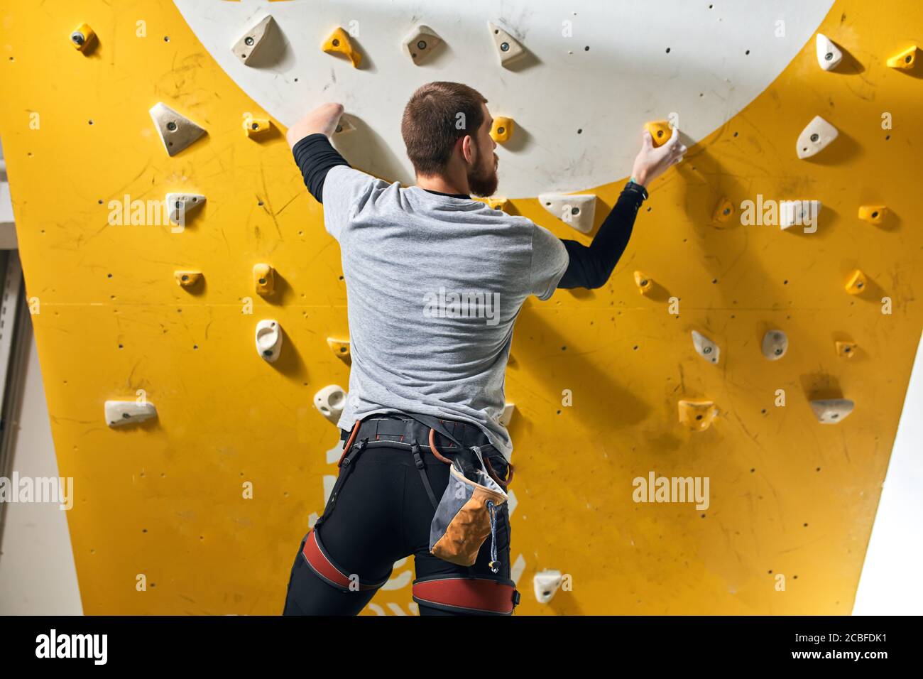Back view of unrecognizable powerful boulderer standing in front of ...