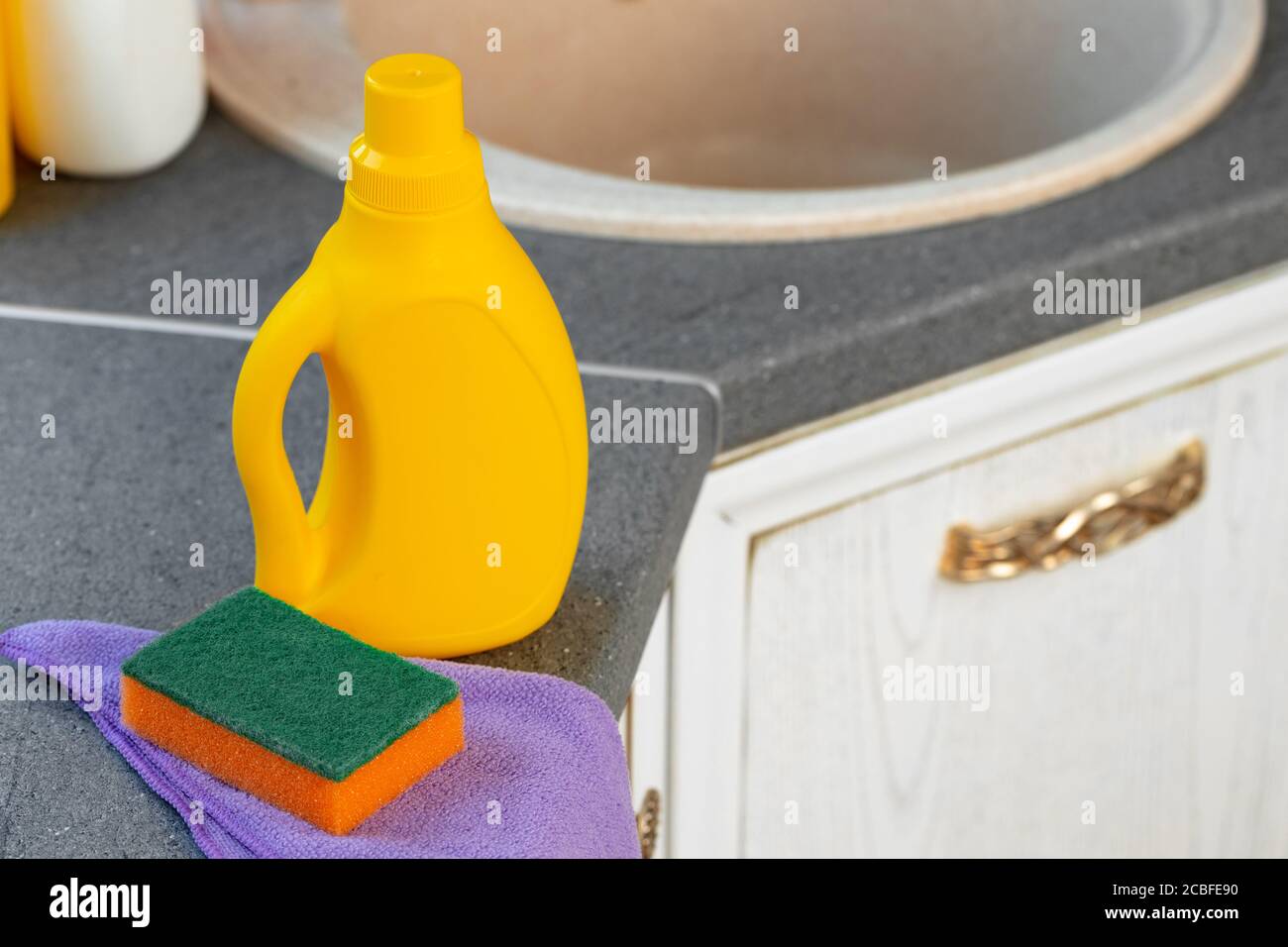 Cleaning detergents and tools on a kitchen counter Stock Photo - Alamy