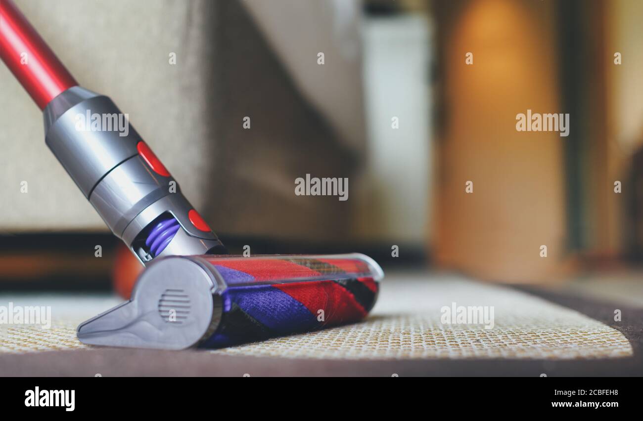 Modern vacuum cleaner while vacuuming. woman using a vacuum cleaner ...