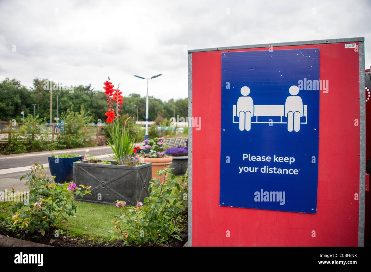 Blue and white ‘Please keep your distance’ poster fixed to a red ...