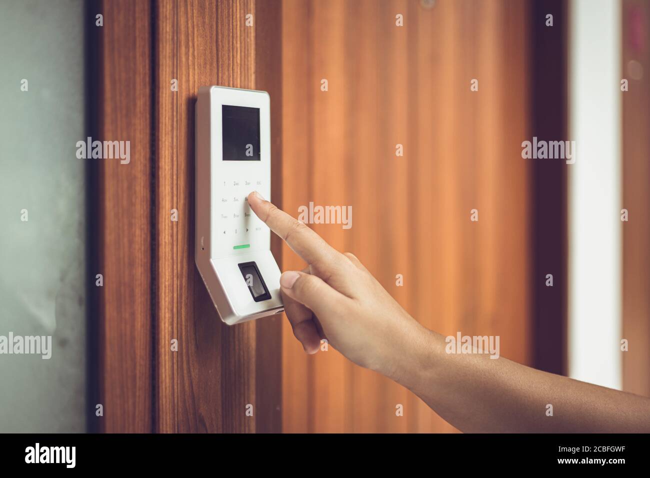 hand typing password at electronic door lock and security system panel ...