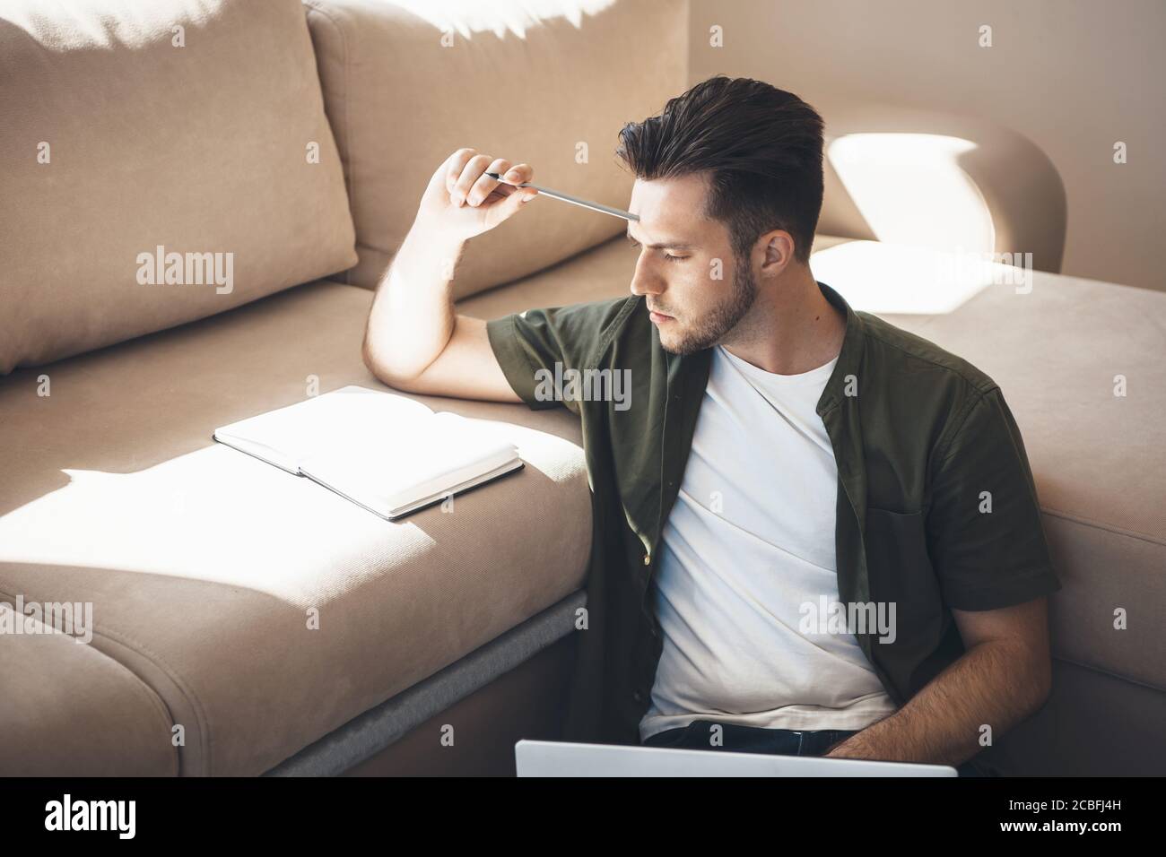 Thoughtful caucasian man reading something in the notebook and holding ...