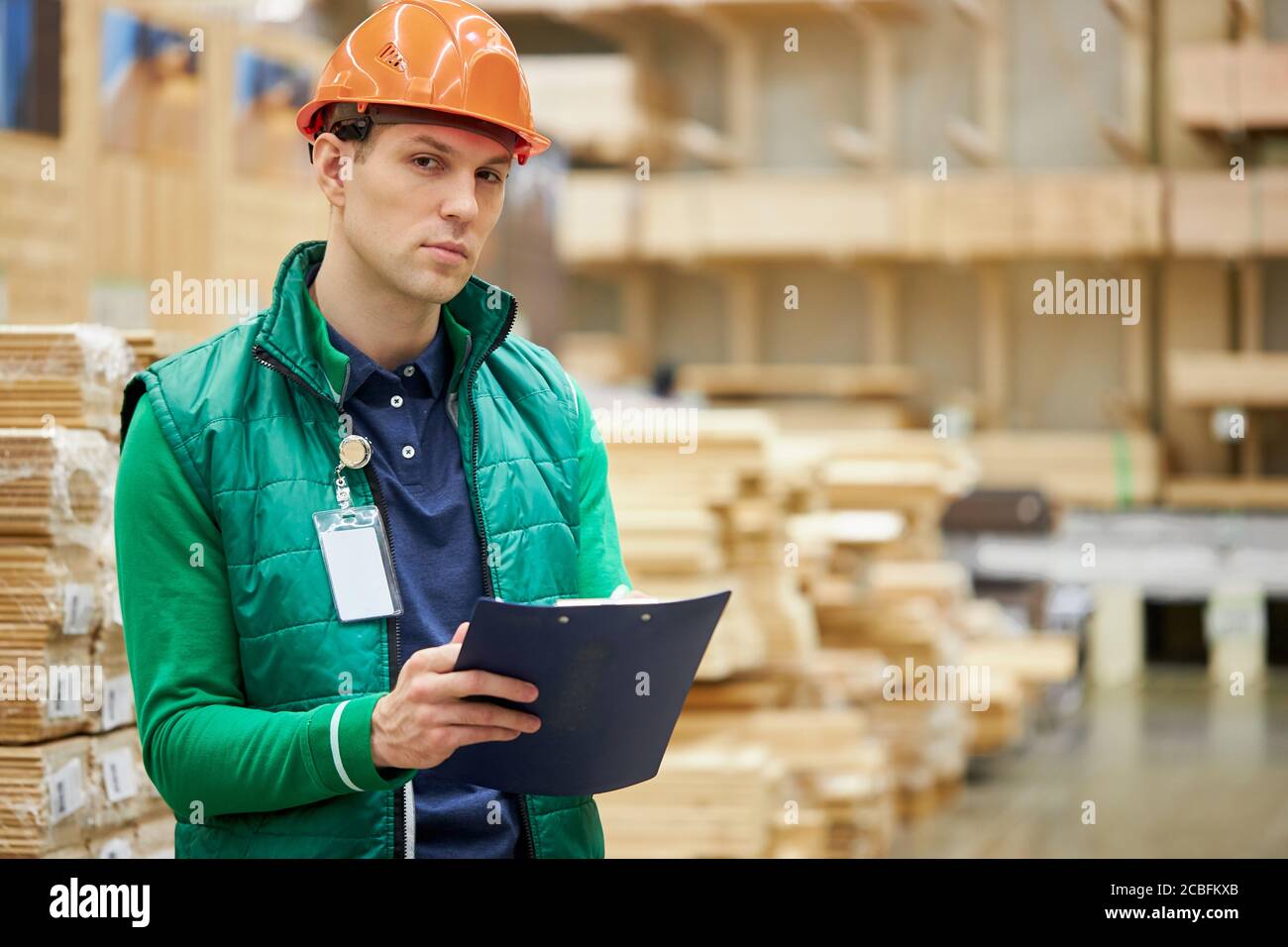 handsome guy in uniform, confident warehouse worker write the number of ...