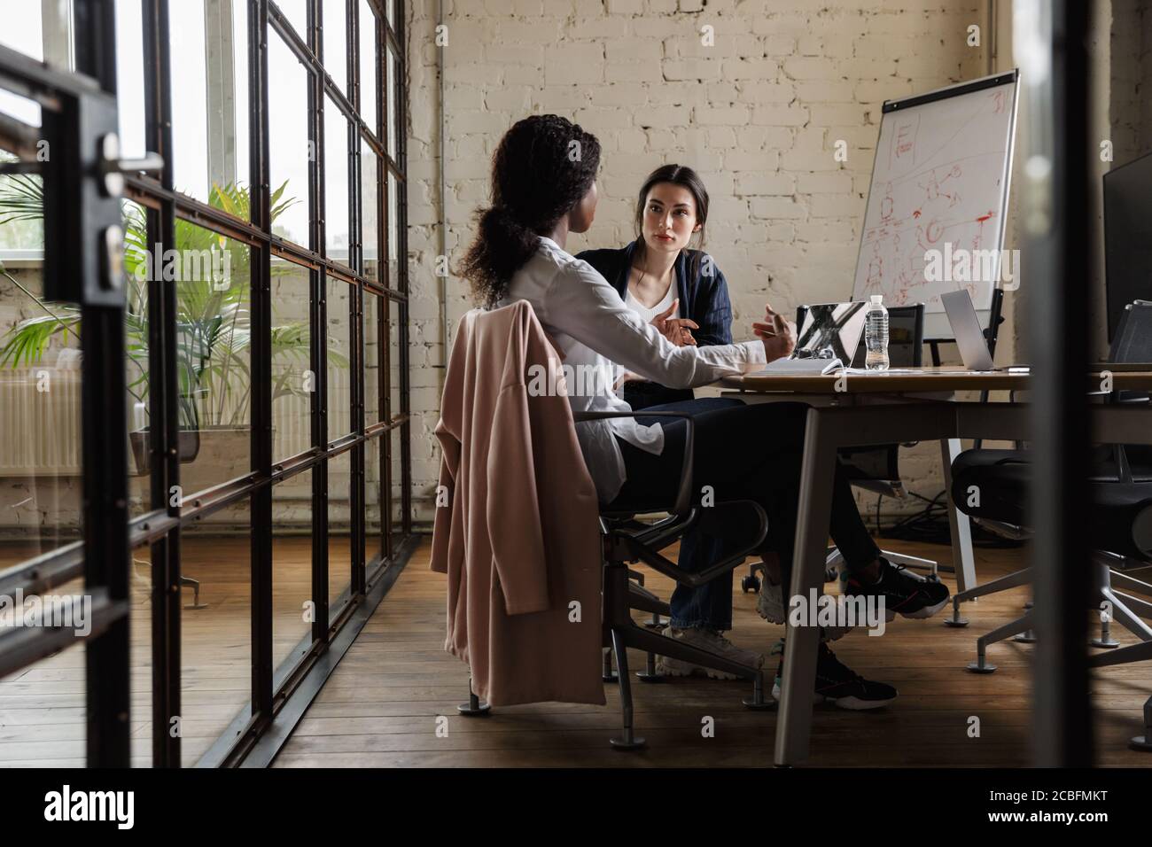 Two attractive smart multiethnic women entrepreneurs working over new ...