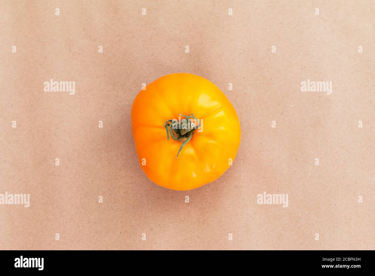 Yellow big tomato isolated on beige color background Stock Photo - Alamy