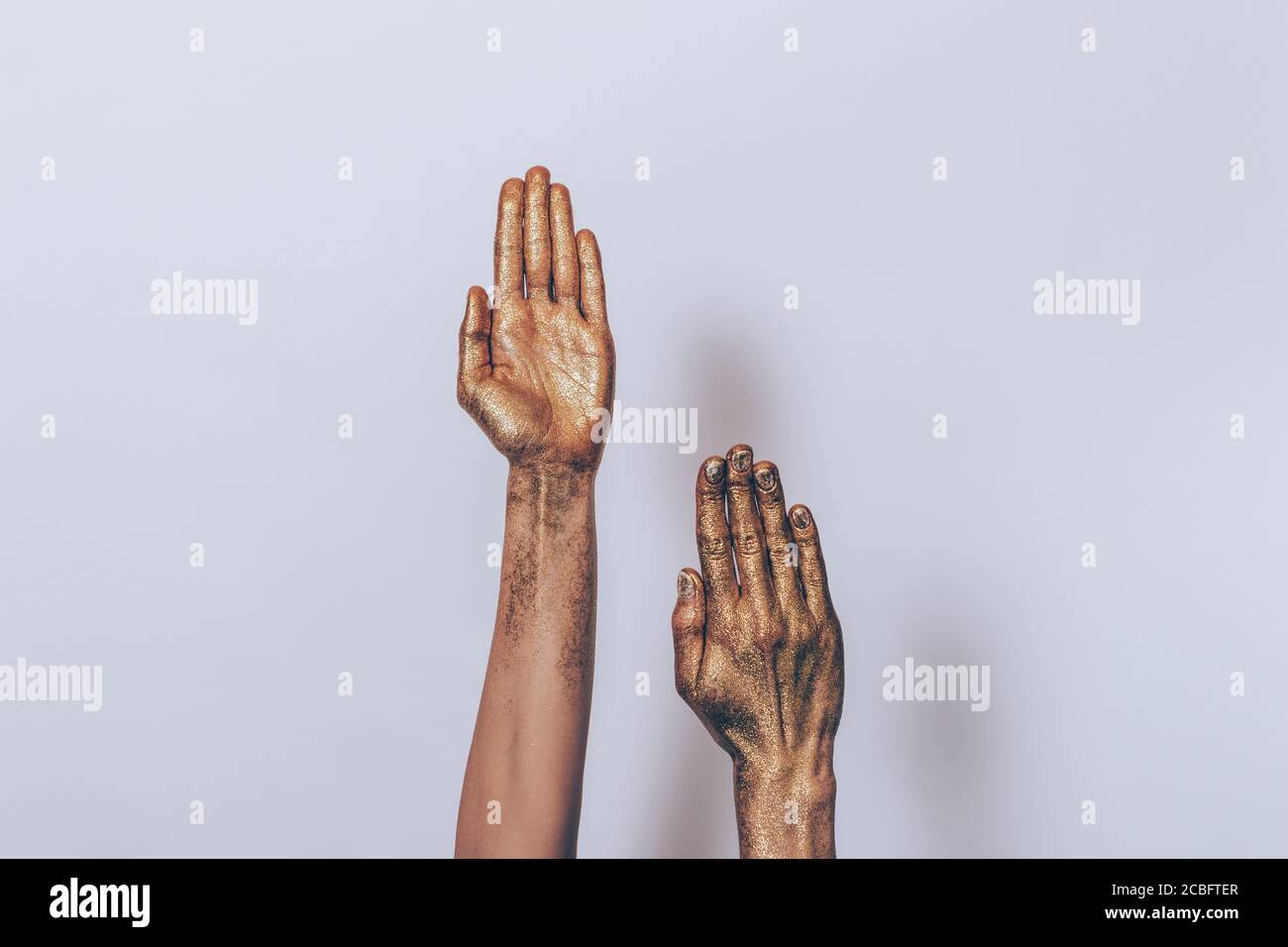 Women's hands in gold paint on a white background Stock Photo - Alamy
