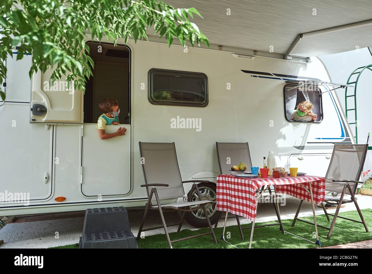 Brothers on vacation in a caravan. They have a face mask for corona ...