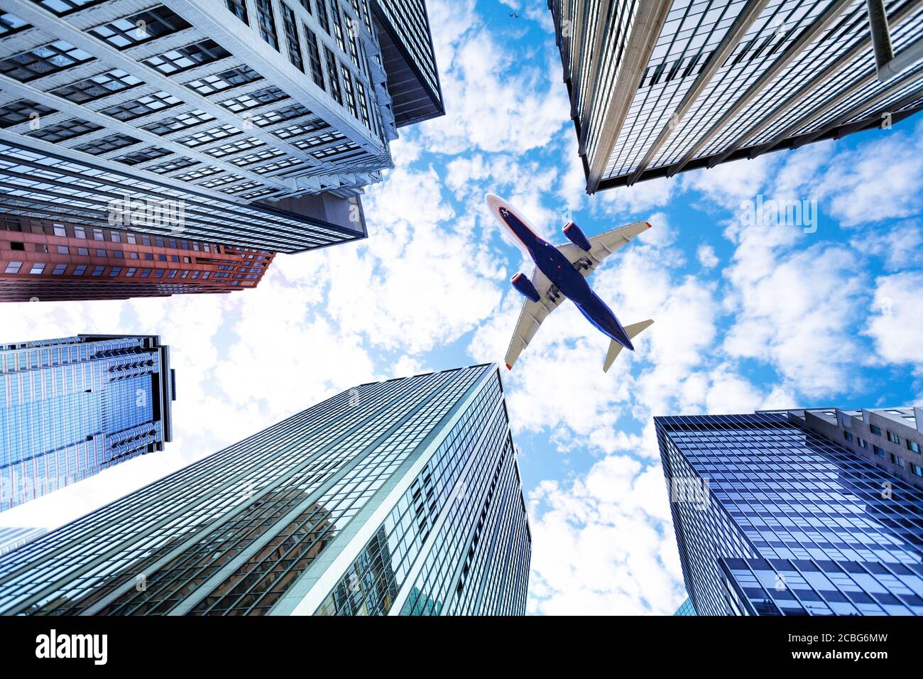 Airplane over sky between skyscraper buildings in New York Stock Photo ...