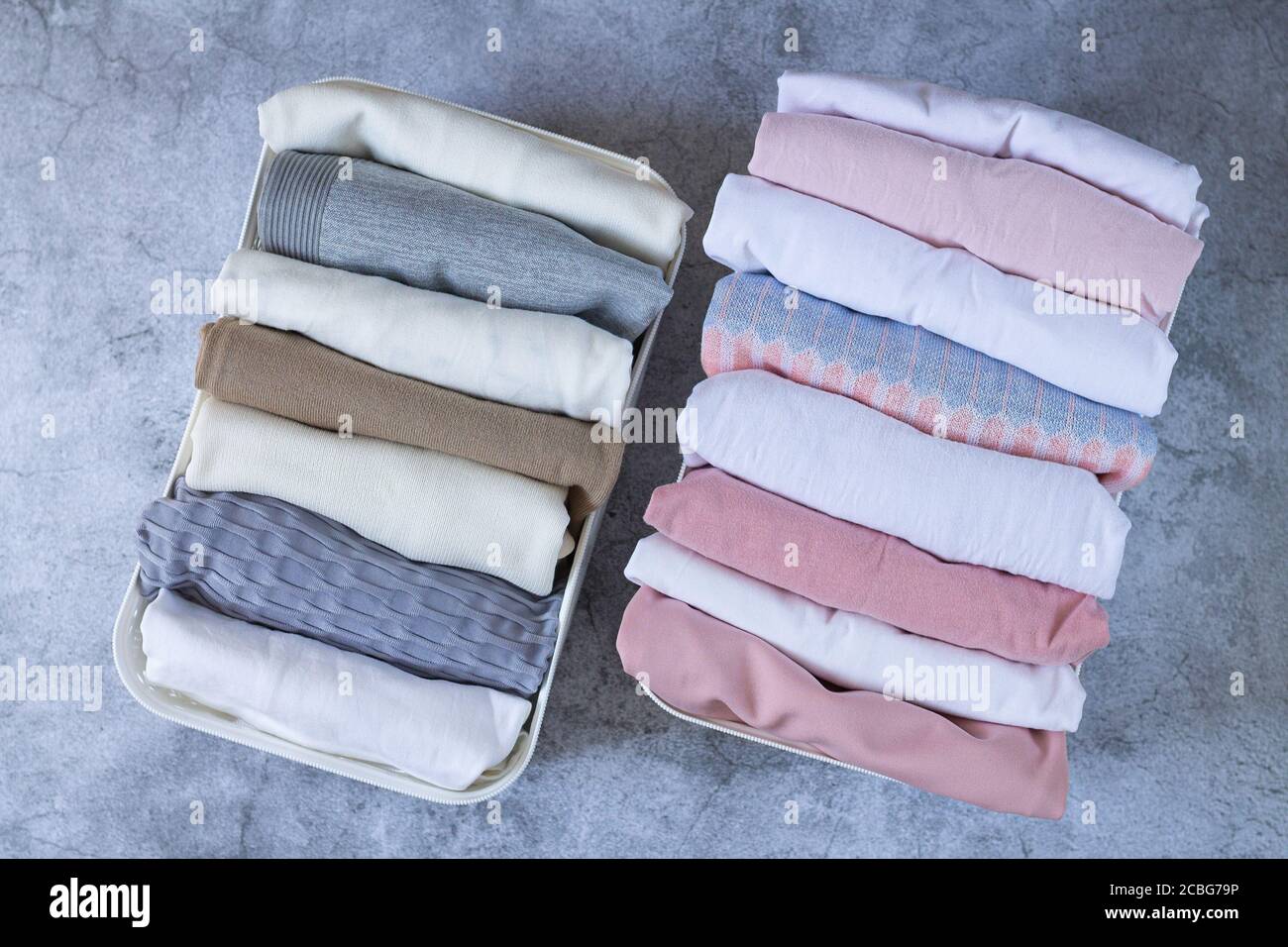 Neatly folded clothes in open organizer boxes top view on stone table ...