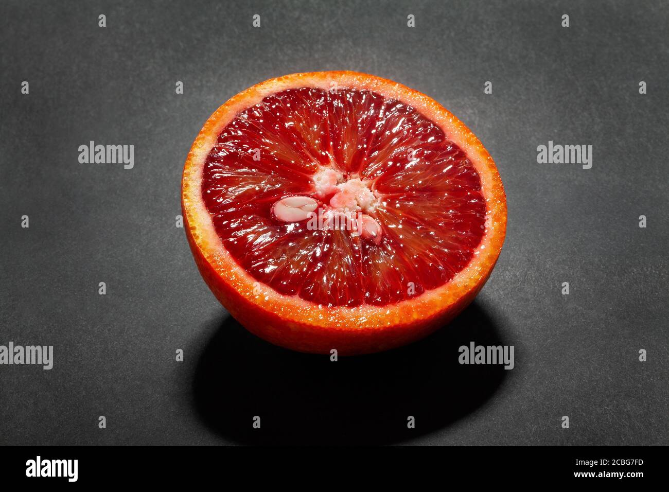 sliced blood tangerine on black background Stock Photo - Alamy