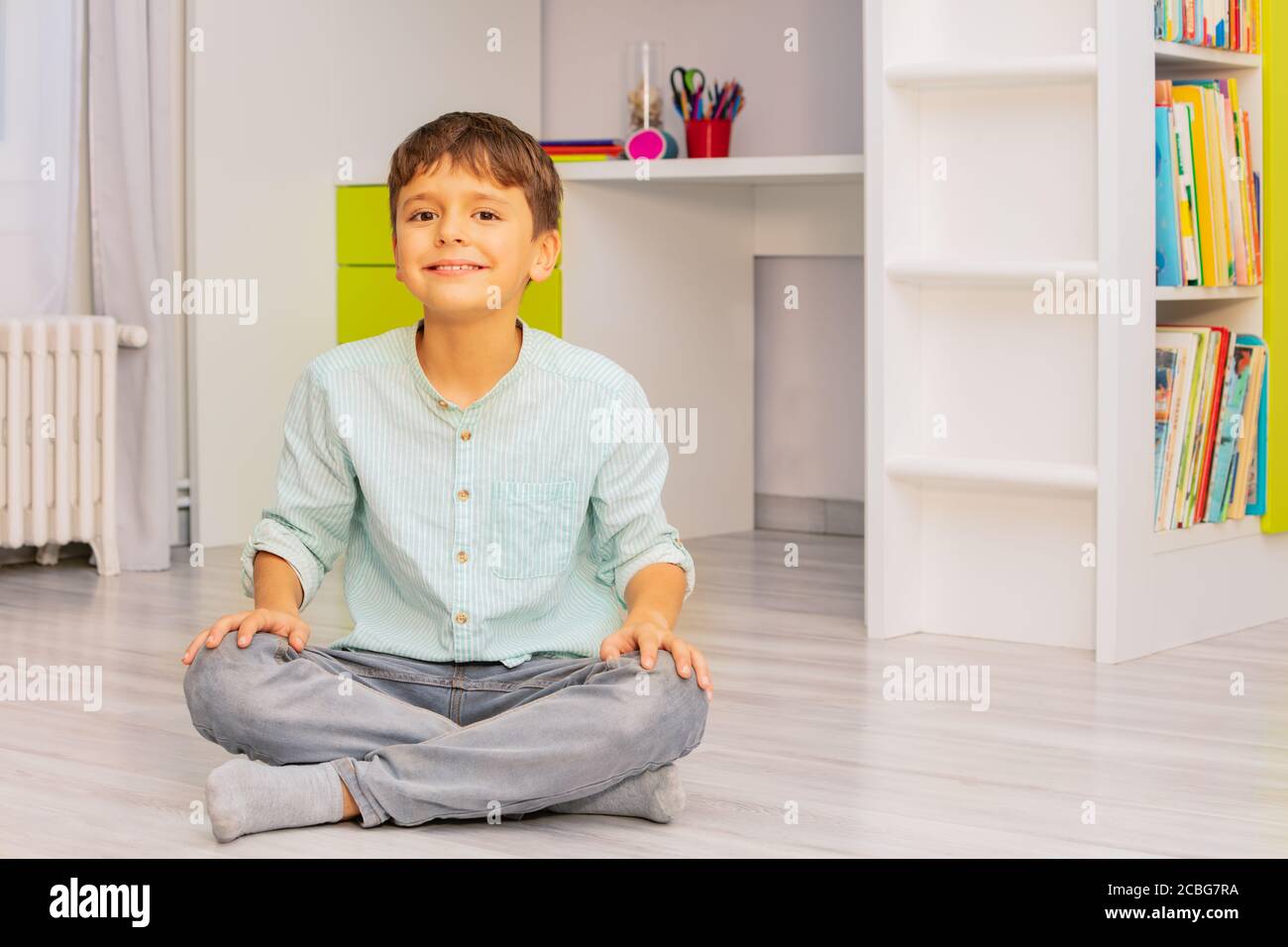 Smiling calm little boy sit in his room with positive expression Stock ...