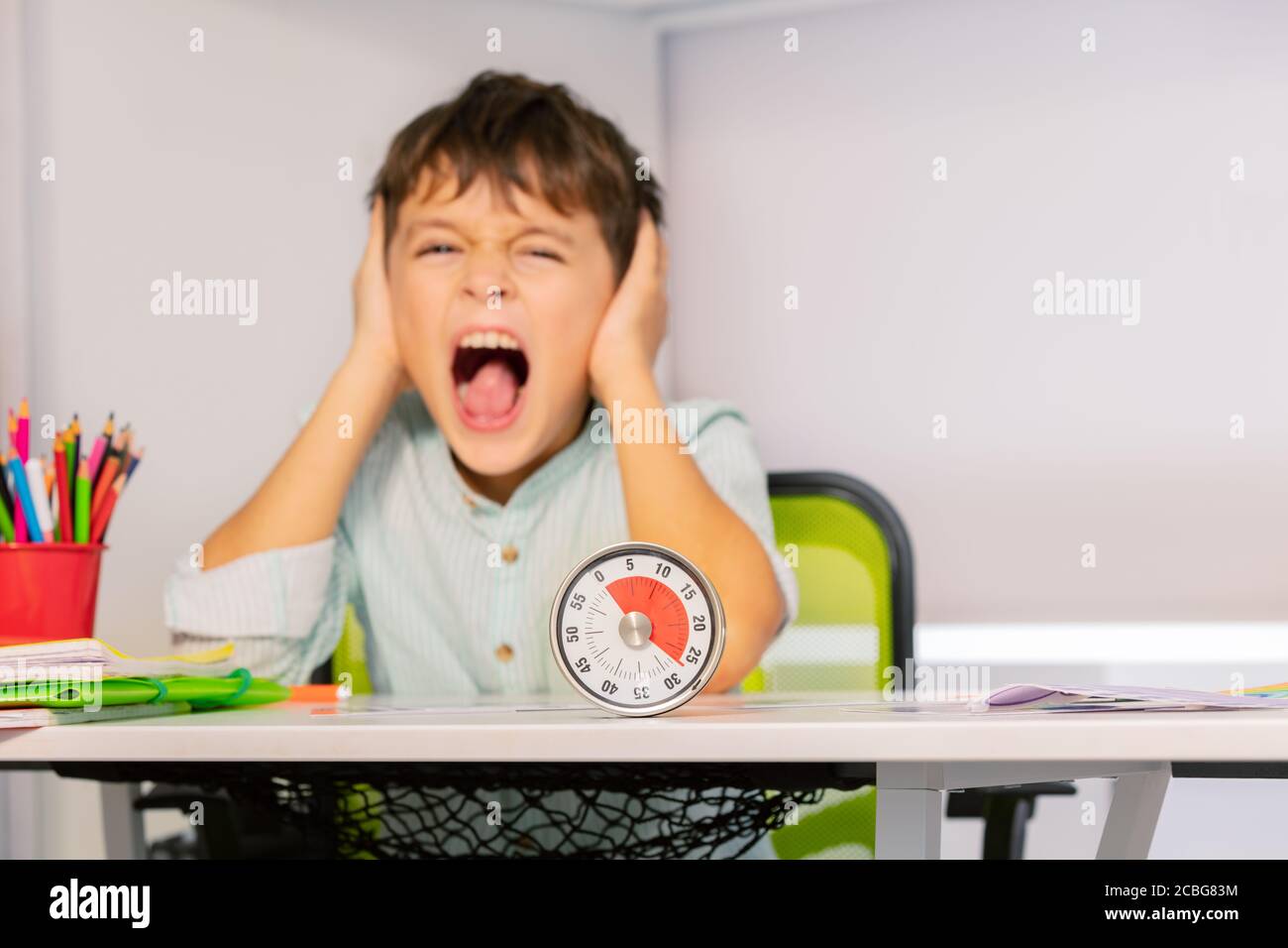 Sad screaming autistic boy portrait close ears using hands during ...