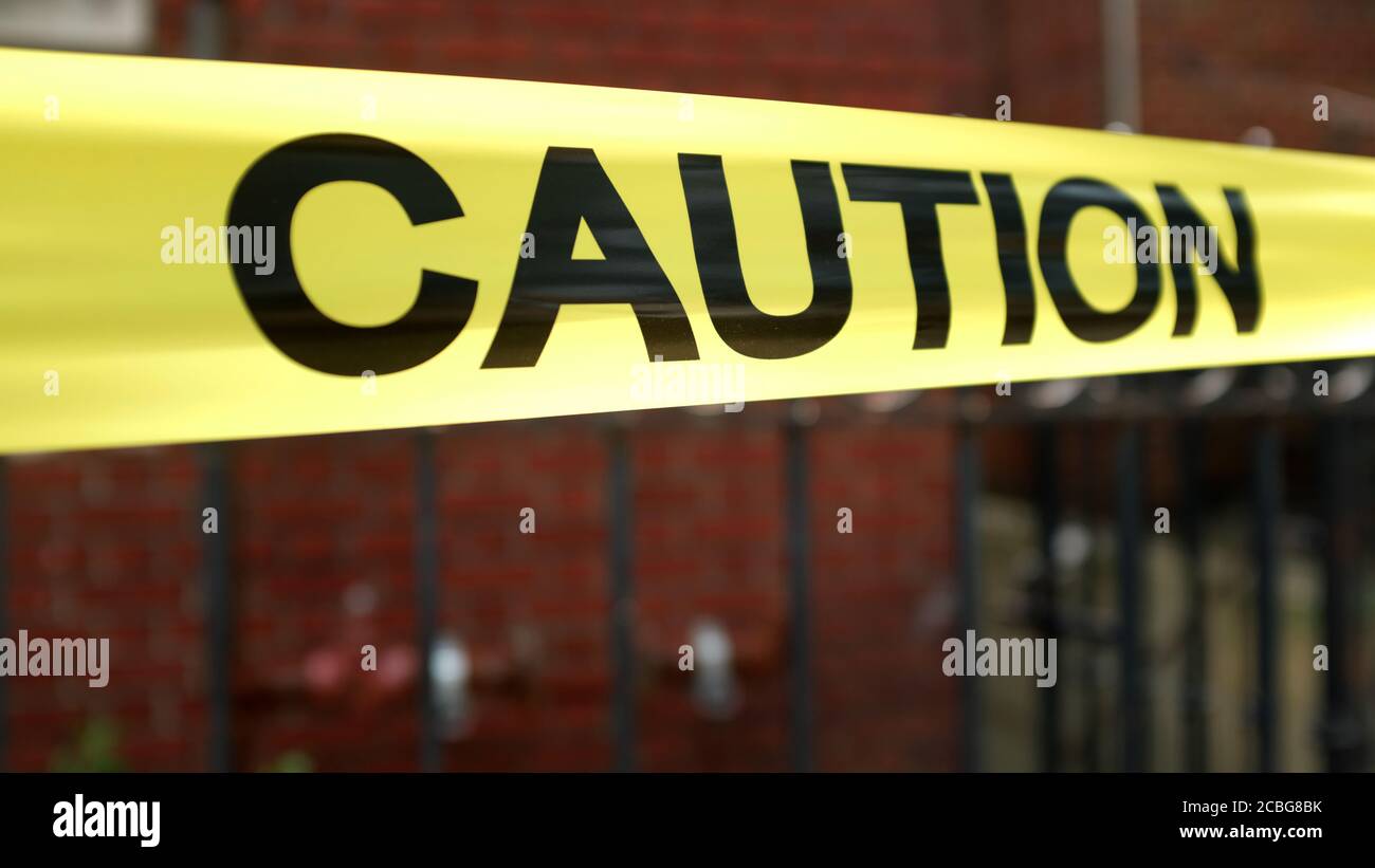 Yellow Caution Tape in Front of Red Brick Building Stock Photo - Alamy