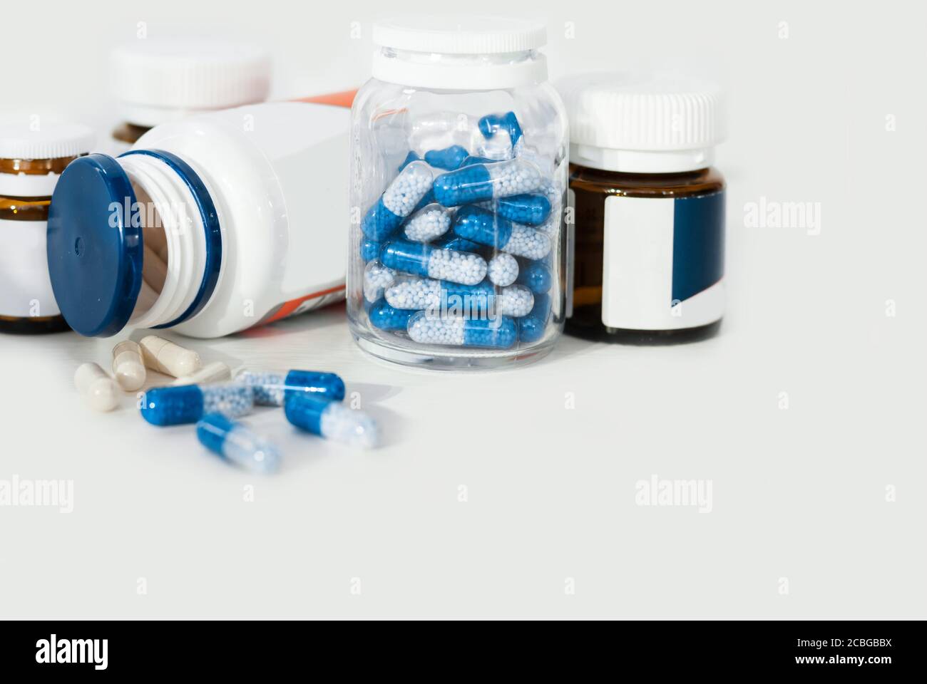 Blue pills in glass and plastic bottles on white background, health ...