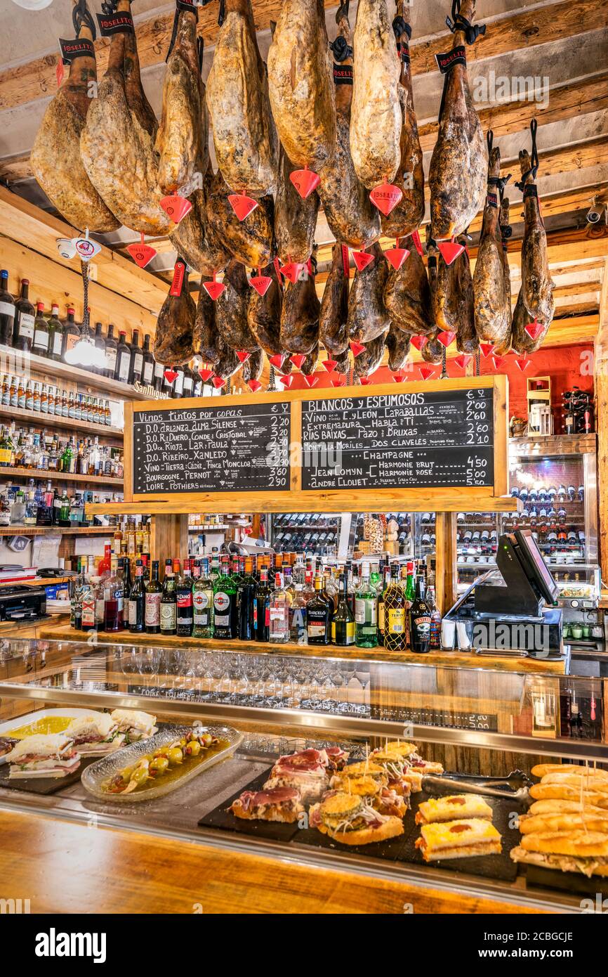Spanish hams hang from the ceiling inside a bar in Burgos, Castile and ...